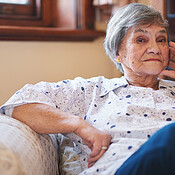 Portrait happy elderly woman smiling sitting on sofa at home enjoying ...