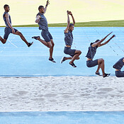 Sequence of a young fit male athlete jumping in a sandpit competing in ...