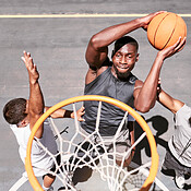 Basketball players from above blocking a player from dunking a ball ...