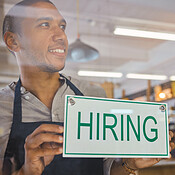 Small business owner advertising with hiring sign board on a window or ...