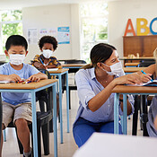 Covid learning with teacher and school students having lesson, study and education in class ...