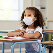 Child or student in class during covid, wearing a mask for hygiene and ...