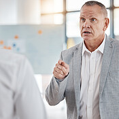 Angry businessman, finger pointing or argument or fight at workplace ...