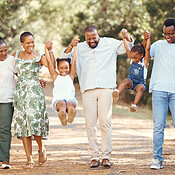 Happy black family bonding and having fun at a park together, laughing ...