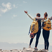 Hiking friends celebrate climbing mountain peak together on rocky ...