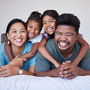 Portrait of a happy Asian family on the bed with a smile on their face ...