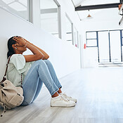 Sad, depression and anxiety student woman on floor in university campus ...