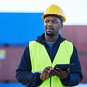 Tablet, black man and cargo planning logistics for shipping company ...