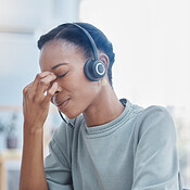 Stress, burnout and sad call center worker with a headache and office ...