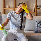 Spring cleaning, tired and sad woman headache in home living room with ...