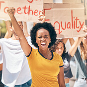 Protest, crowd of people and black woman in the street, fist in air ...