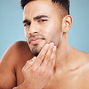 Skincare, portrait and man in blue studio thinking of facial hair ...