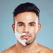 Shaving cream, face and portrait of man in a studio to shave his beard with foam or creme ...