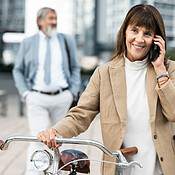 Phone call, bicycle and senior woman cycling to work while talking ...