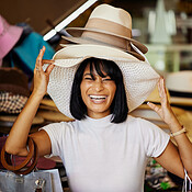 Woman, hats and smile of a black woman shopping at a retail store with ...