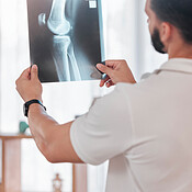 Man, physiotherapist and x ray scan analysis in sports clinic for ...