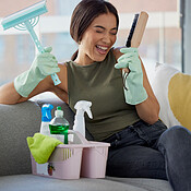Cleaning, housework and woman sitting on sofa with smile, detergent and ...