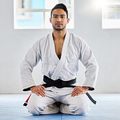 Portrait, karate and sensei with a sports man kneeling on the gym floor ...