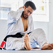 Karate, sports injury and neck pain of man at fitness club for martial ...