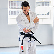 Karate, arm pain and man with injury in dojo, healthcare and fighting ...