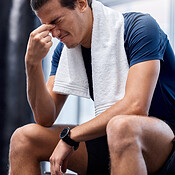 Man, gym exercise and tired with headache at training, workout or ...
