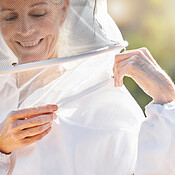 Bee farming, woman and beekeeper with suit for safety, ready to work ...