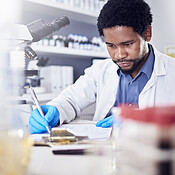 Black man writing report for science study, scientist in lab for ...