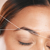 Eyebrows, grooming and woman threading hair on face for beauty routine ...