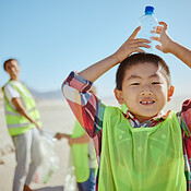 Child, portrait and plastic bottle on nature beach, waste management ...