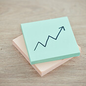 Growth, investment and success with arrow on sticky note for finance ...