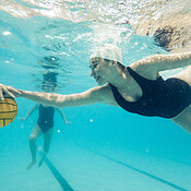 Water polo, catching and women underwater for a ball during a ...