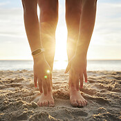 Stretching, fitness and feet of woman at beach for relax, wellness and ...