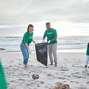 Teamwork, charity and recycling with people on beach for sustainability ...