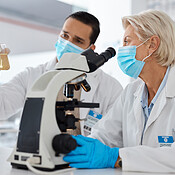 Science, mask and man with woman, liquid and experiment with cure ...