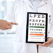 Hands, tablet screen and eye chart in hospital for vision examination ...