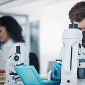 Man, doctor and forensic science with microscope for examination ...