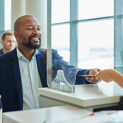 Ticket, glass window and black man in airport or hotel line for ...