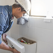 Toilet, plumbing worker and man at cistern of home renovation, builder ...