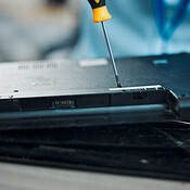 Laptop, technician and fixing with screwdriver, technology maintenance ...