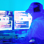 Hacker, programmer and woman typing on laptop in home at night in neon ...