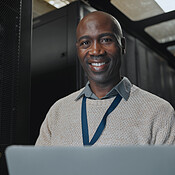 Laptop, portrait and IT black man in server room for research, engineer ...