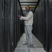 Laptop, maintenance and server room with IT black man for research ...