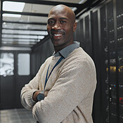Black man, IT technician in server room and portrait with smile ...