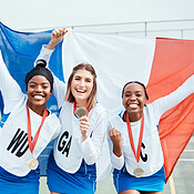 Netball win, flag portrait and sports team celebration, excited or ...