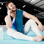 Phone call, fitness and male relaxing after training, workout or ...