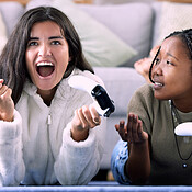 Celebrate, controller and friends playing a game in the living room for ...