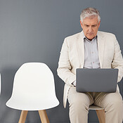 Mature business man, laptop and waiting room, queue and interview line ...