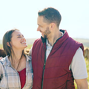 Cow, love and happy couple on a cattle farm hugging, bonding and enjoy ...