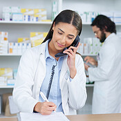 Pharmacist woman answering the telephone and giving advice to customer ...