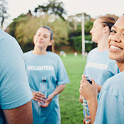 Portrait, smile and volunteer woman with team outdoors for climate ...